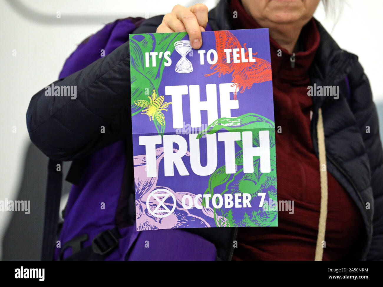 A member of Extinction Rebellion holds up a poster in the South ...