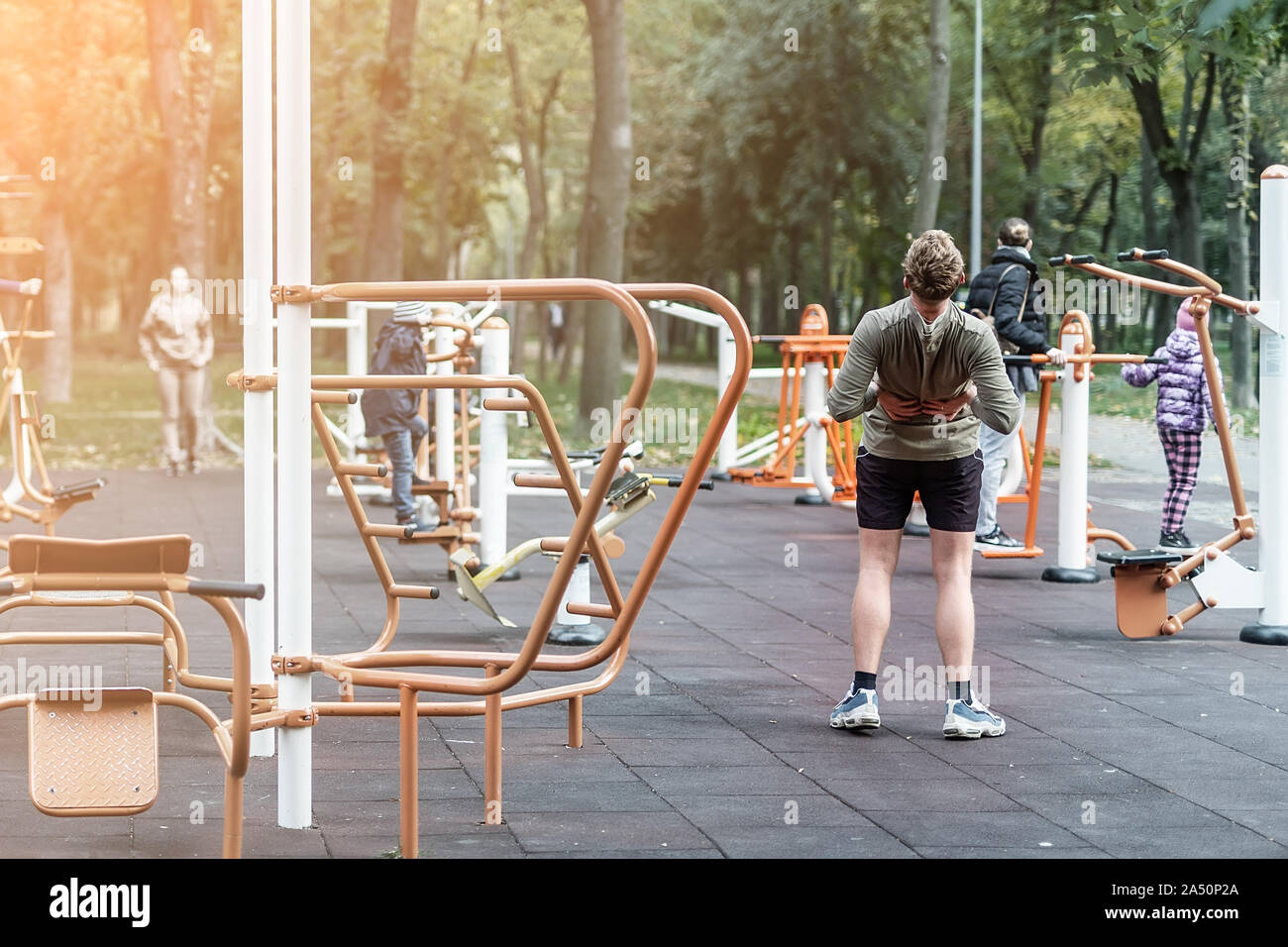 People making sport exercises and training at public outdoor gym area ...