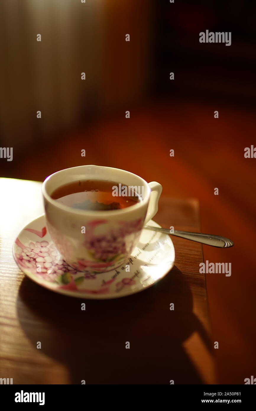 Black tea in an elegant cup on the sunny table Stock Photo - Alamy