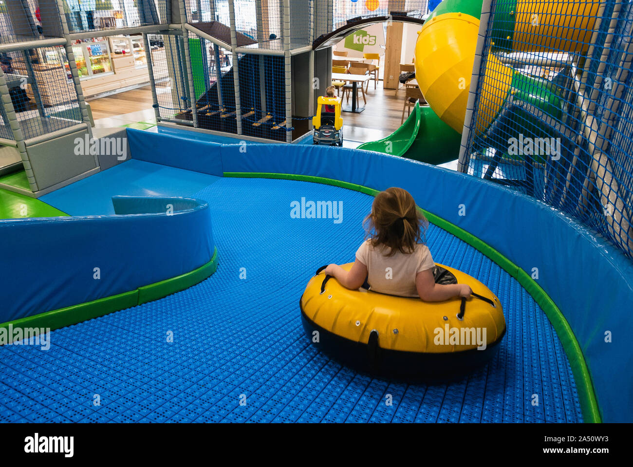 Little girl rides in wheel on the slide in children play center Stock ...