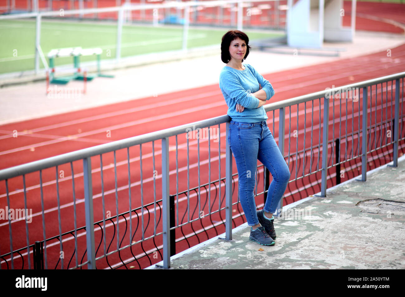 Beautiful woman in the stadium. Portrait of a fitness woman resting at ...