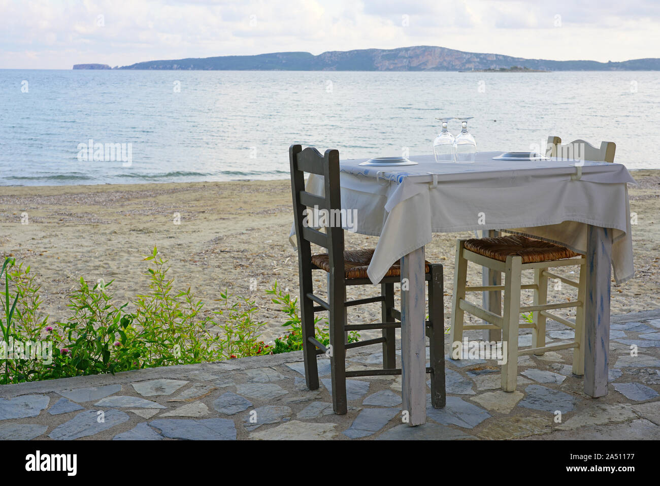 Table set on the beach at a traditional Greek taverna in Gialova on the ...