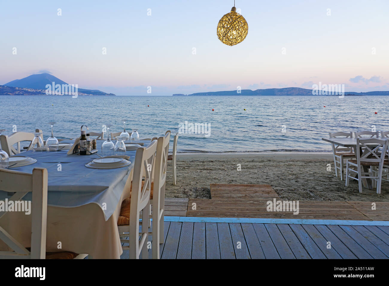 Table set on the beach at a traditional Greek taverna in Gialova on the ...