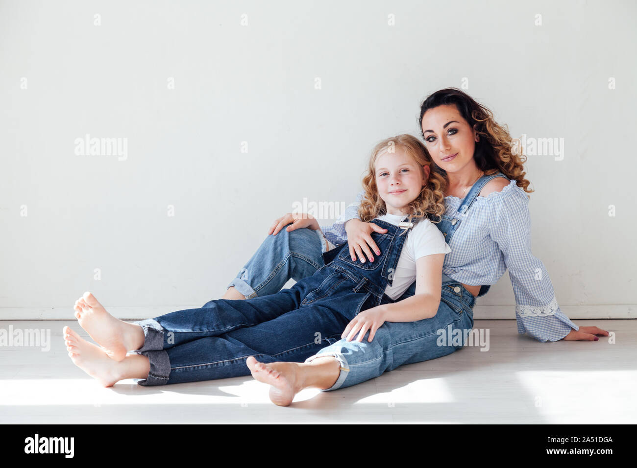Mom and daughter in jeans cuddle laughing Stock Photo - Alamy