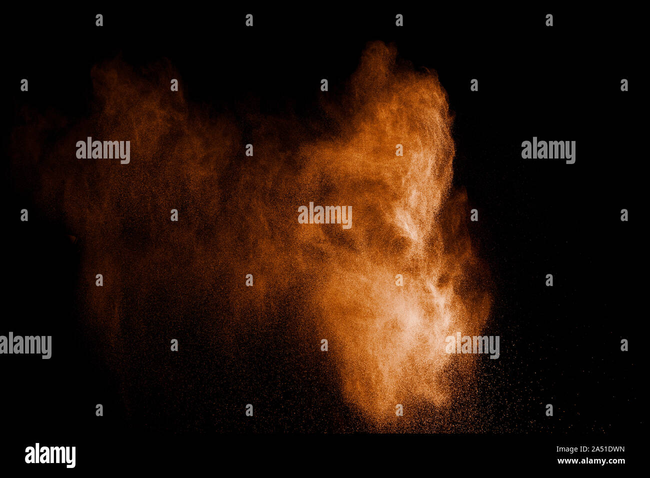 Abstract explosion of orange dust on black background. Freeze motion of ...