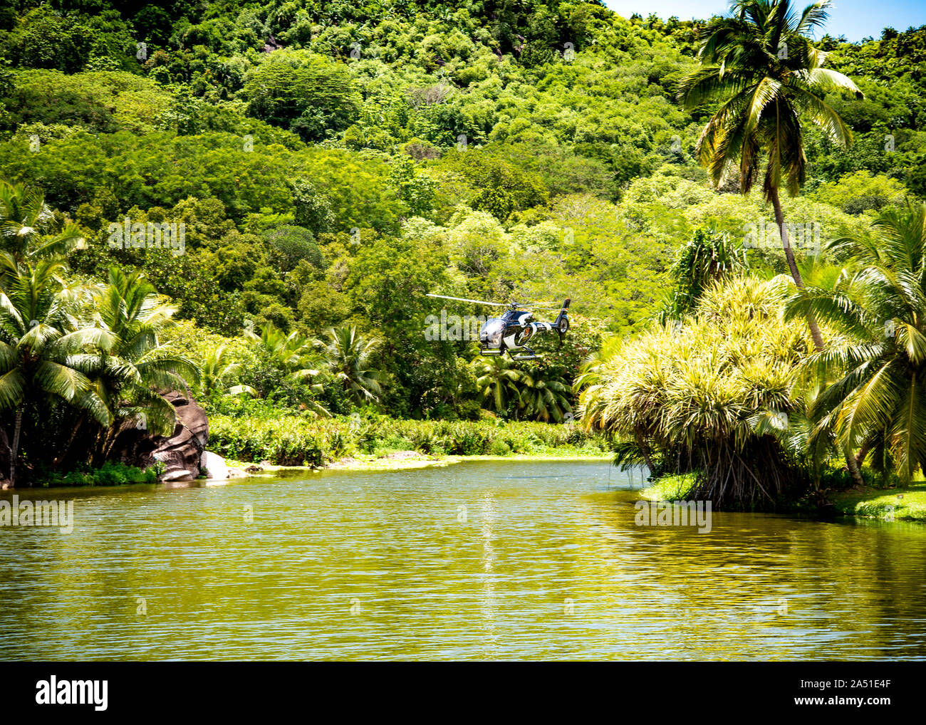 helicopter navigating low along tree lined river,Seychelles Stock Photo ...