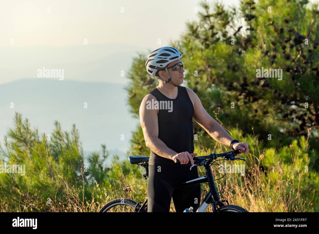 Male cyclist standing with his bike before or after training Stock ...