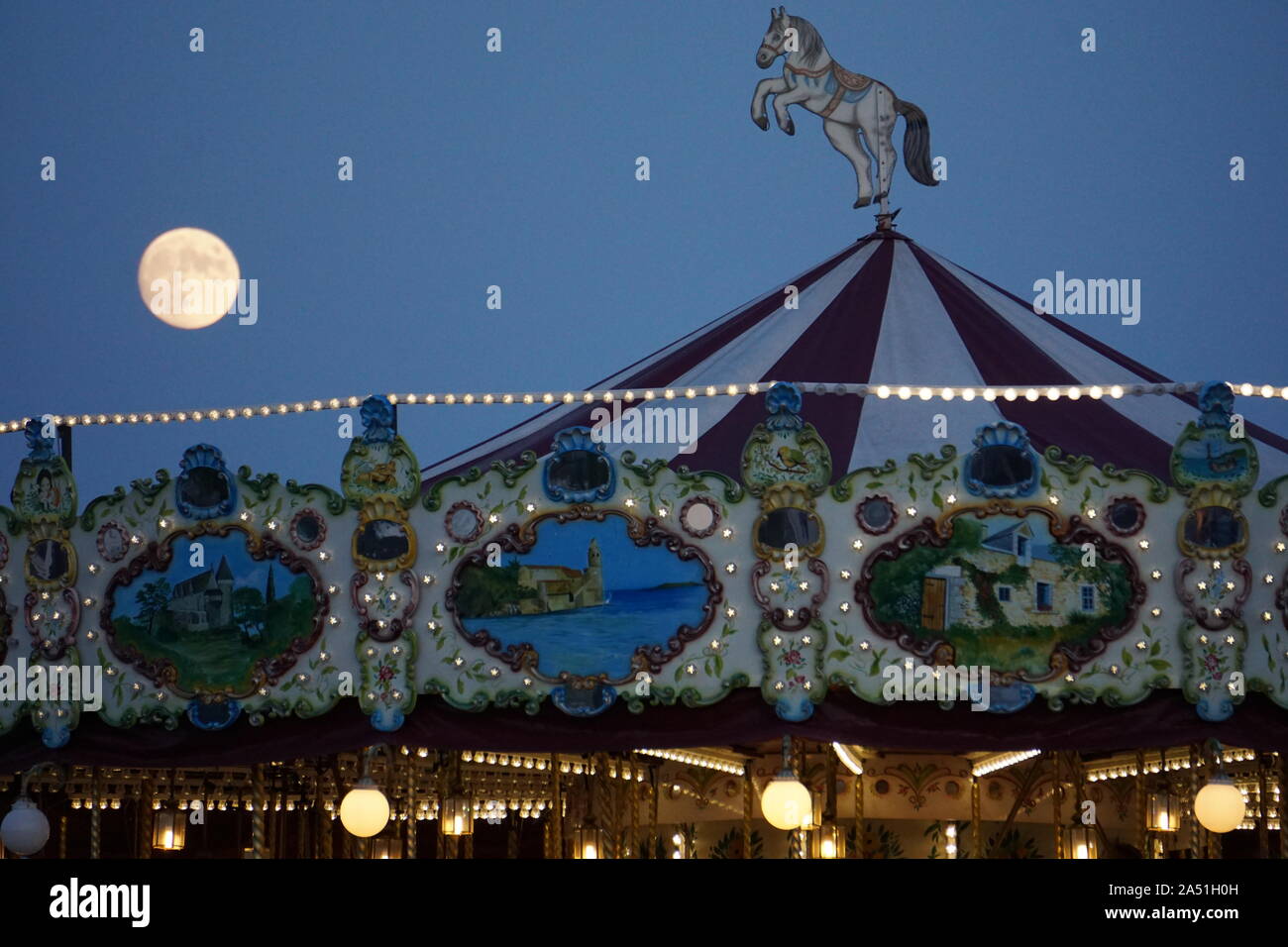 old wooden carousel with full moon rising at dusk Stock Photo - Alamy
