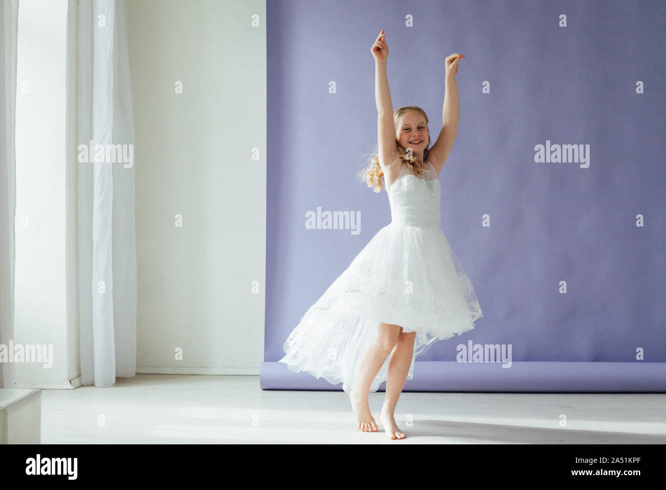 Beautiful blonde girl in dress dancing alone at home Stock Photo - Alamy