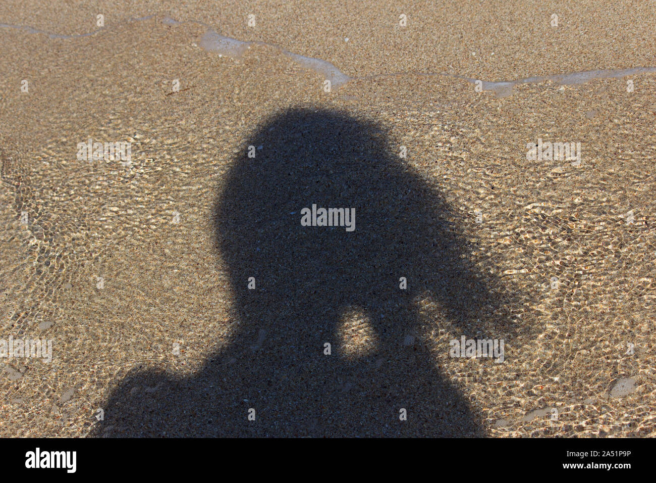 shadow of a girl on the background of the oncoming sea wave. Sandy ...