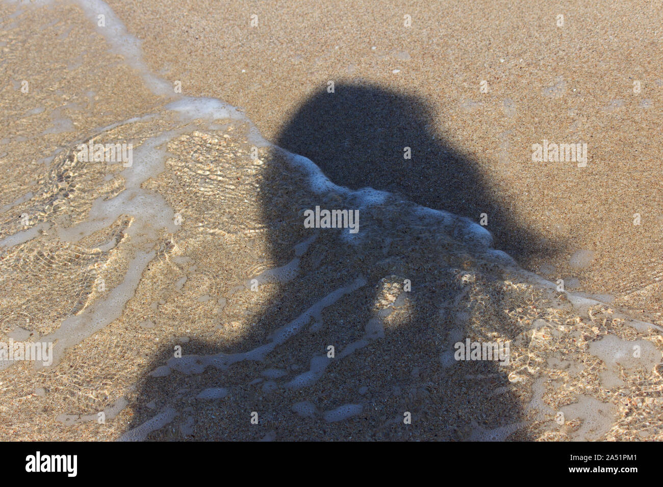 shadow of a girl on the background of the oncoming sea wave. Sandy ...