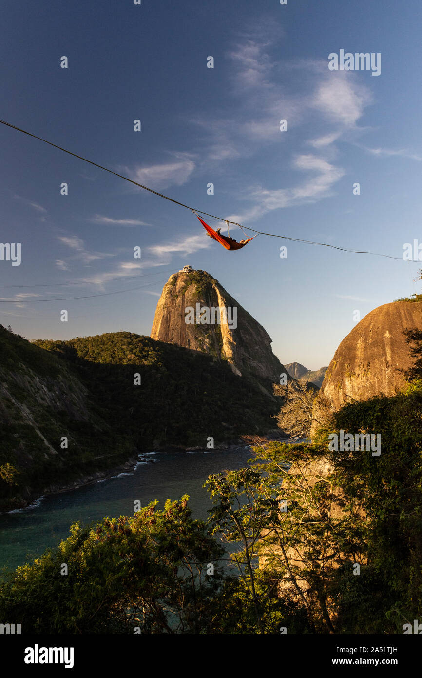 Slackliner resting on climbing net hanging from highline with Sugar ...