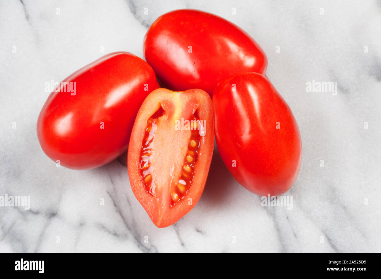 Studio shot of ripe, Italian plum tomatoes on a marble background ...