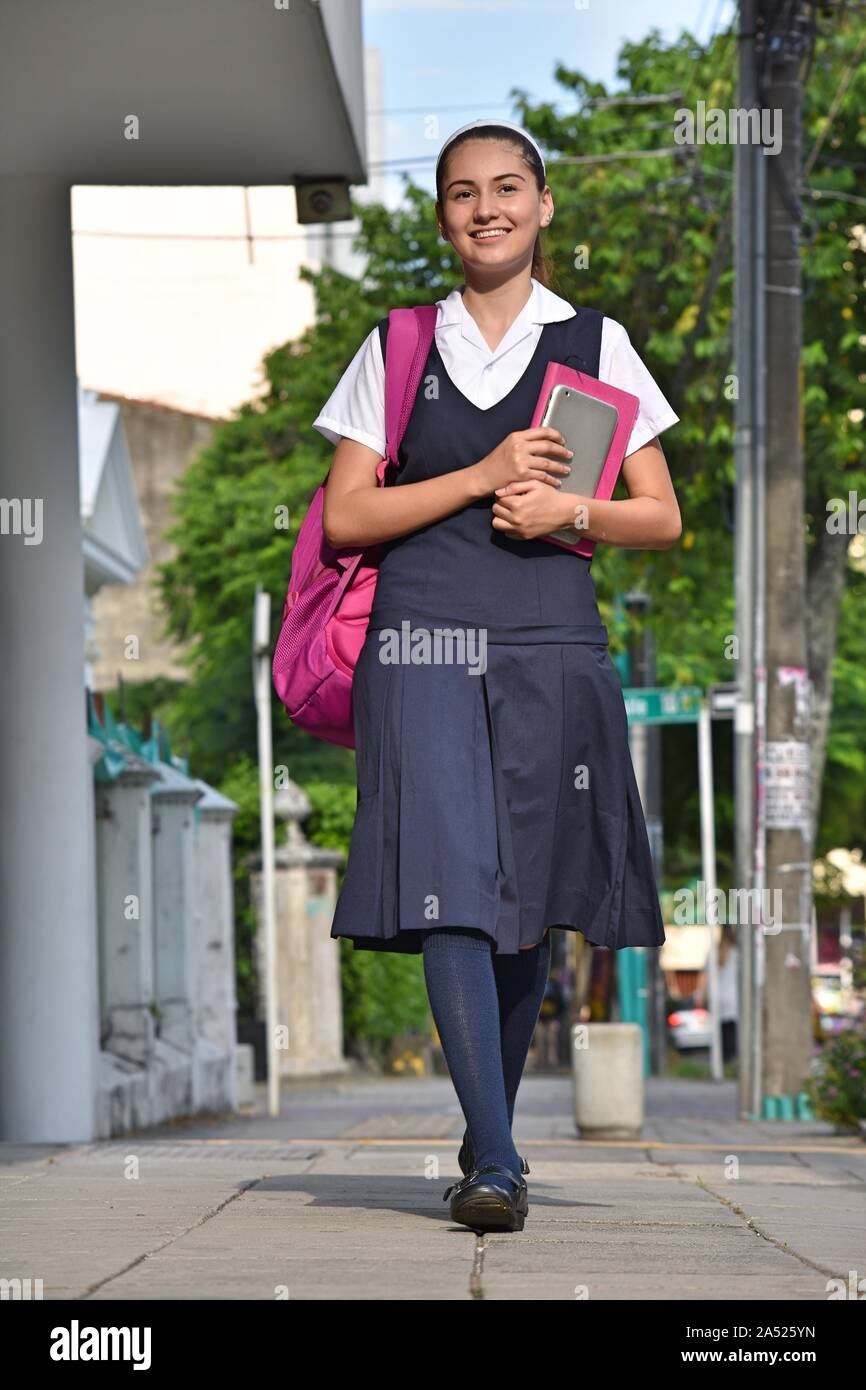 Female Student Wearing Uniform Walking On Sidewalk Stock Photo - Alamy