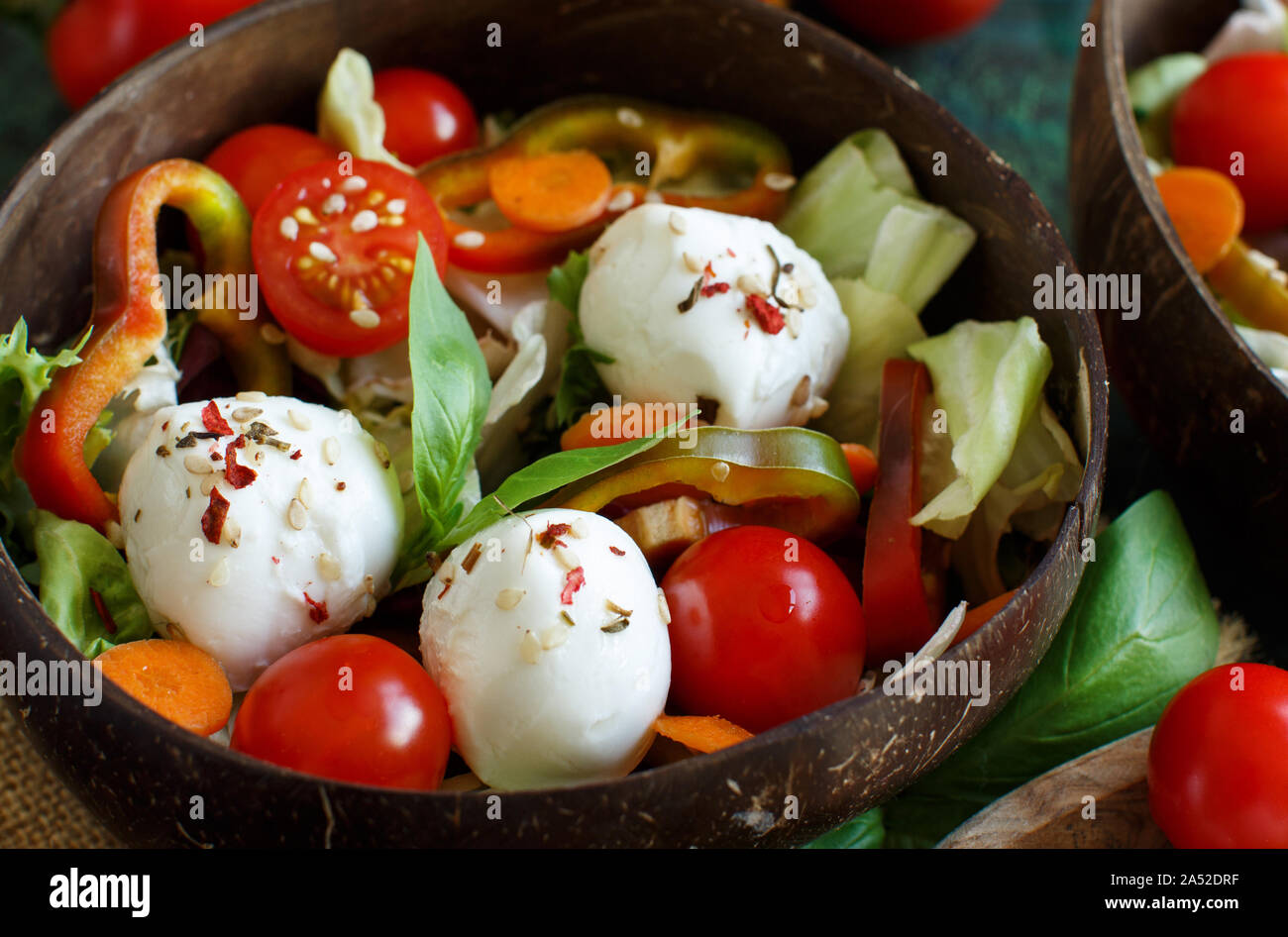 Mixed salad with mozzarella in coconut bowls close up Stock Photo - Alamy