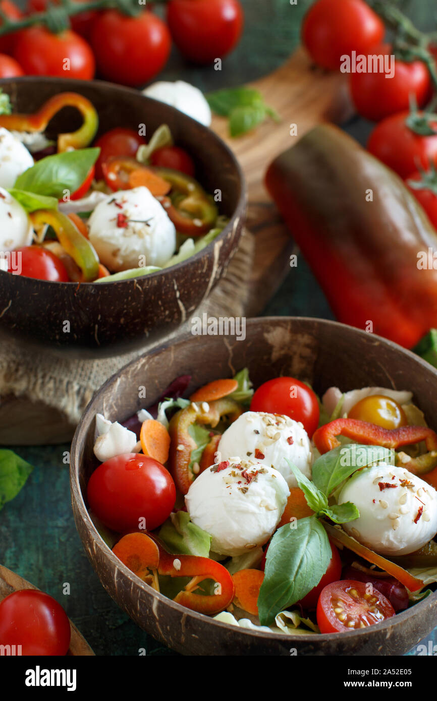Mixed salad with mozzarella in coconut bowls close up Stock Photo - Alamy