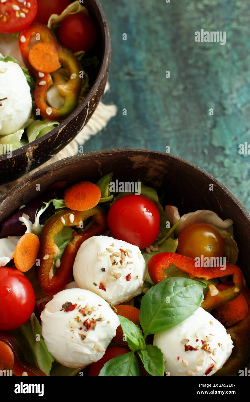 Mixed salad with mozzarella in coconut bowl close up Stock Photo - Alamy