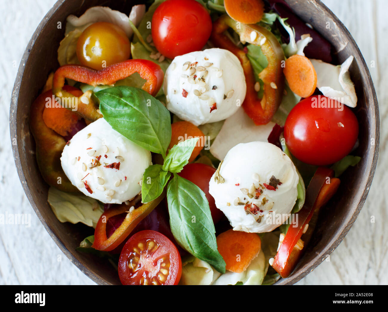 Mixed salad with mozzarella in coconut bowls close up Stock Photo - Alamy