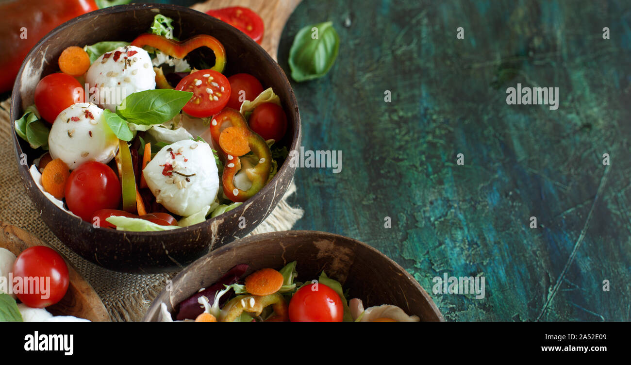 Mixed salad with mozzarella in coconut bowls close up Stock Photo - Alamy