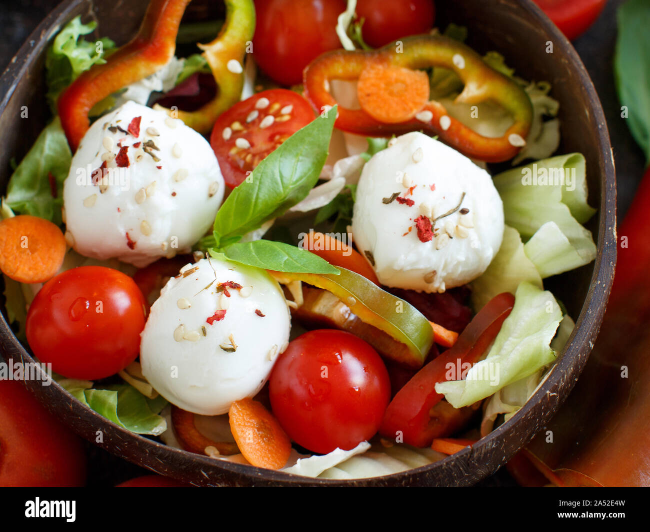 Mixed salad with mozzarella in coconut bowls close up Stock Photo - Alamy