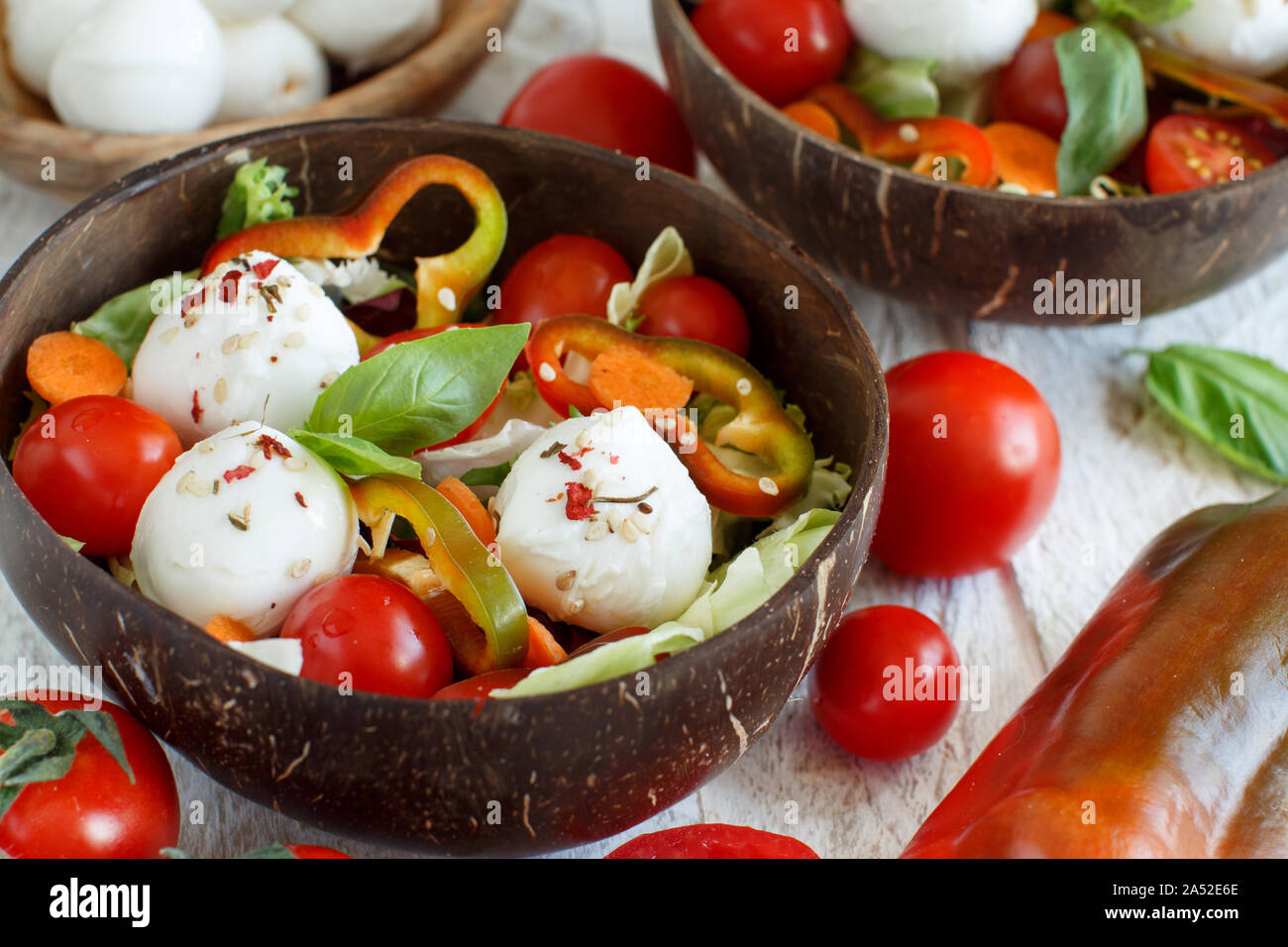 Mixed salad with mozzarella in coconut bowls close up Stock Photo - Alamy