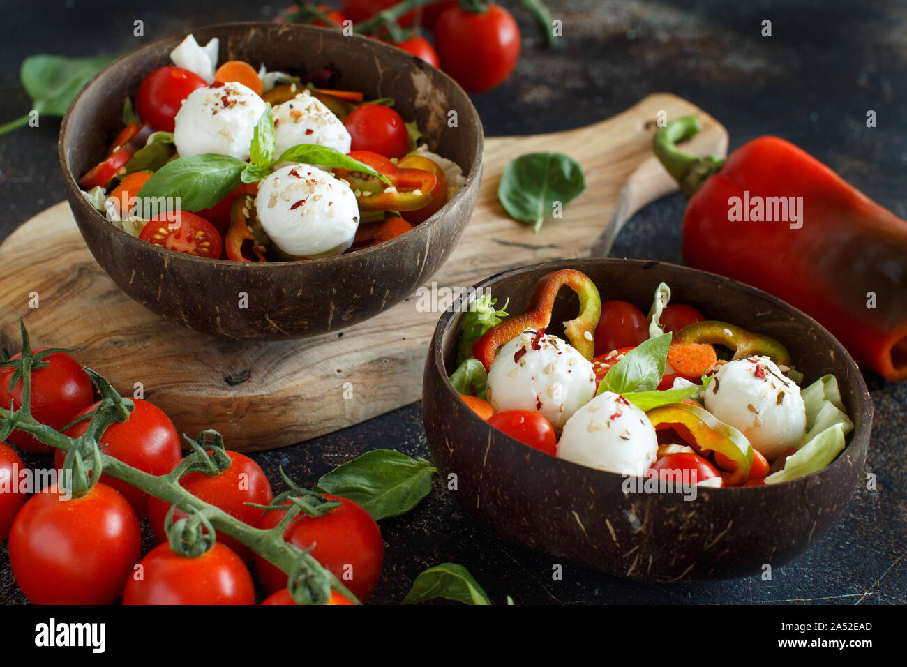 Mixed salad with mozzarella in coconut bowls close up Stock Photo - Alamy