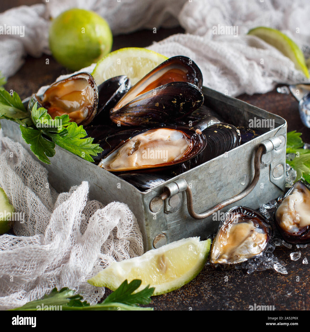 Fresh raw italian mussels with lime and parsley Stock Photo - Alamy