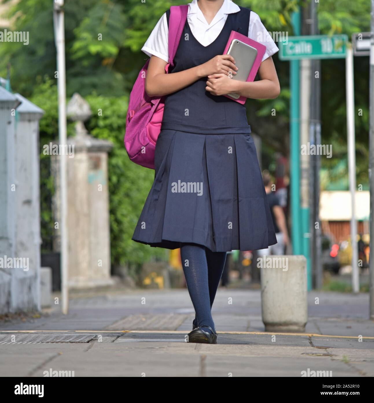 Female Student Wearing Uniform Walking On Sidewalk Stock Photo - Alamy