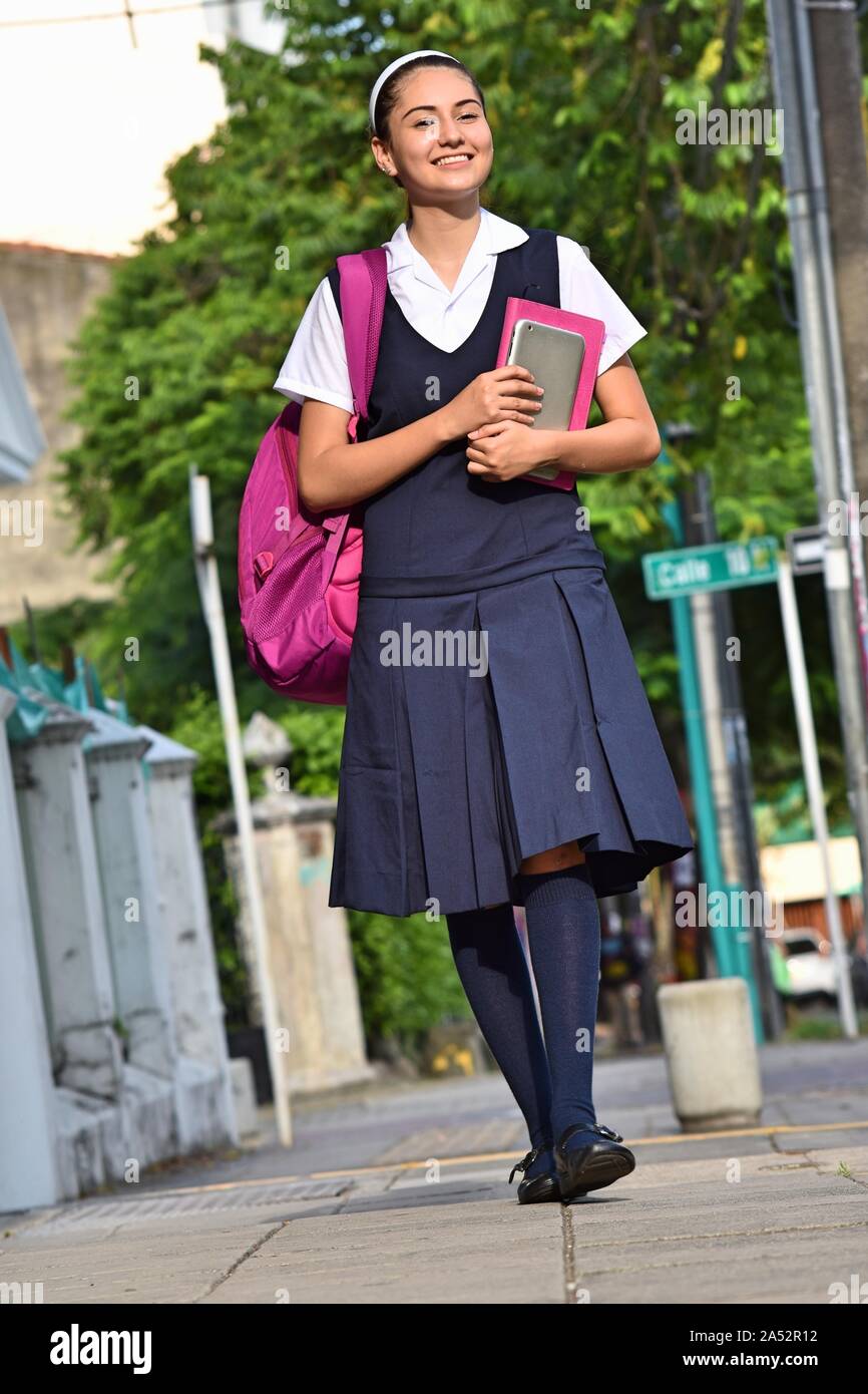 Female University Student Wearing Uniform Walking On Sidewalk Stock ...
