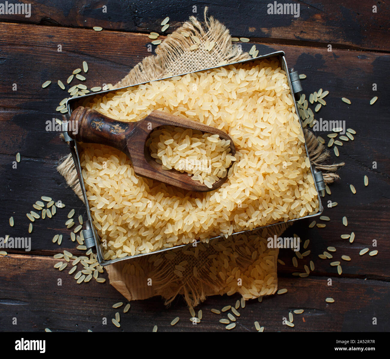 Parboiled rice in a metal box with a wooden spoon top view Stock Photo ...