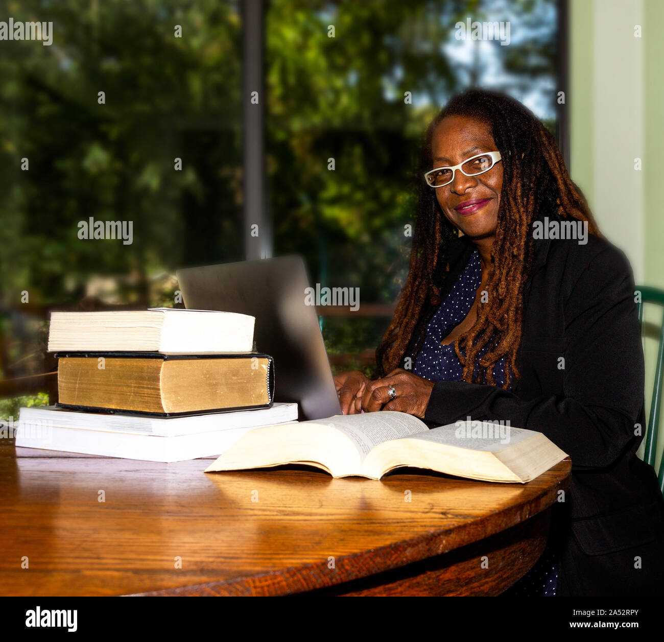 African-American woman at laptop with books Stock Photo - Alamy