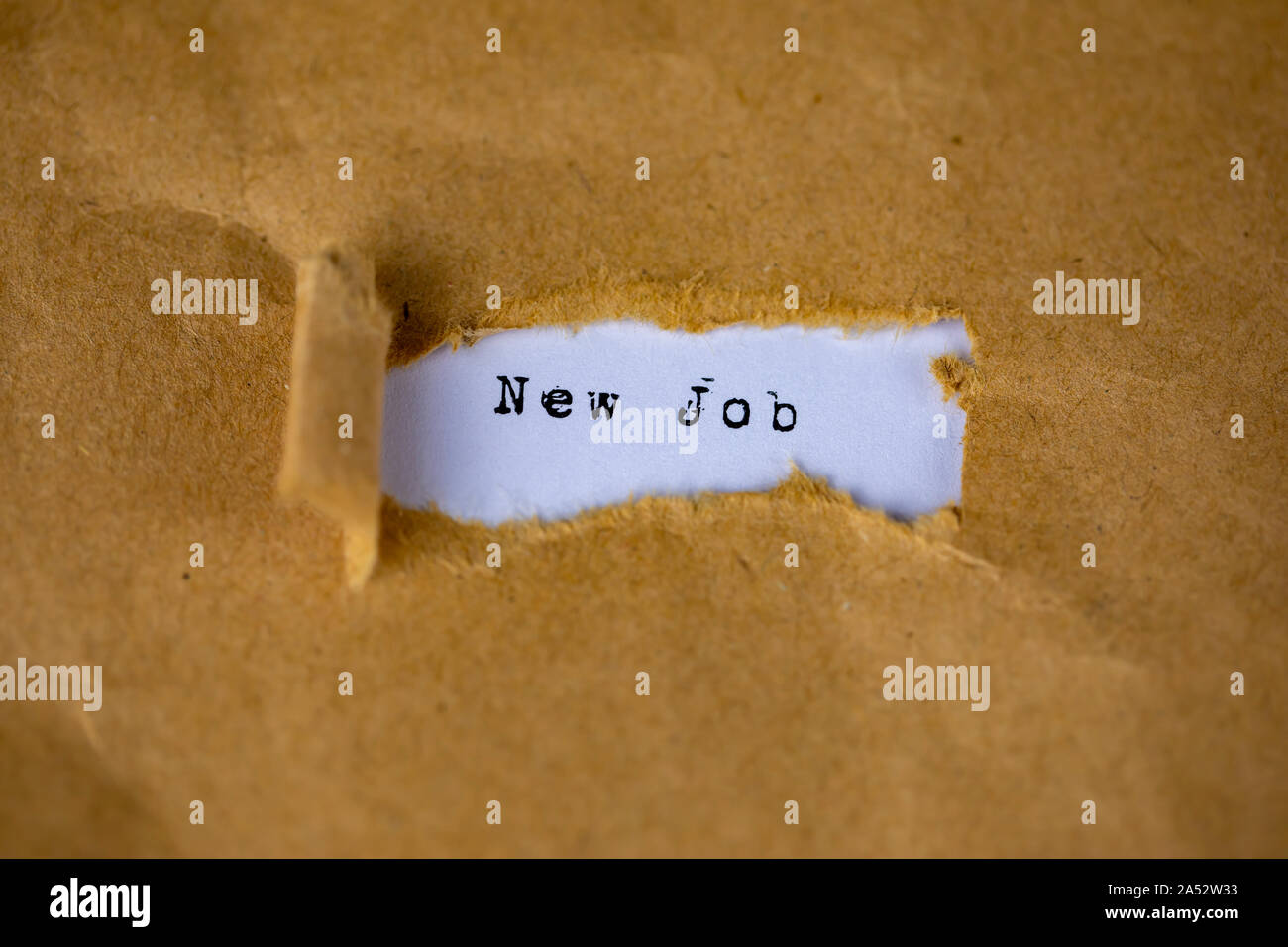 The text, new job, appears behind torn brown paper Stock Photo - Alamy