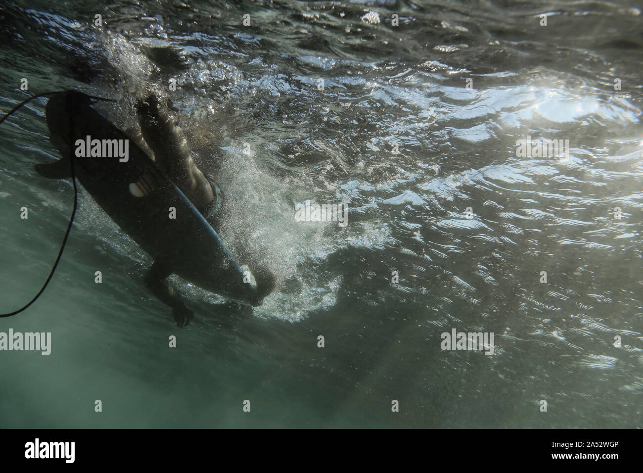 Under water view of wave, surfer sitting on surfboard, underwater shot ...