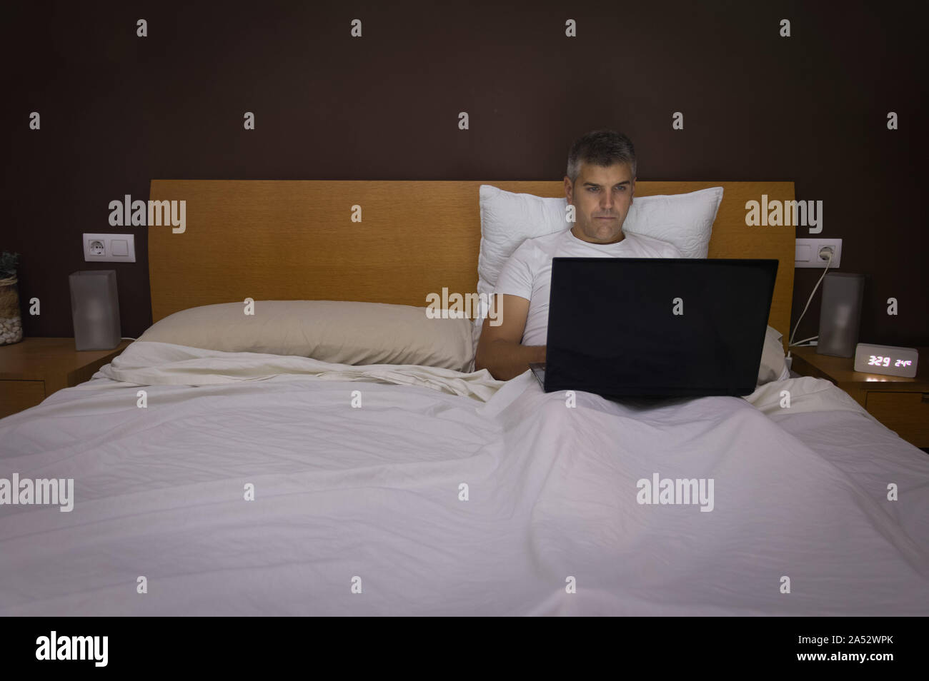 Man working on his laptop in the bed at night. Lifestyle concept Stock ...