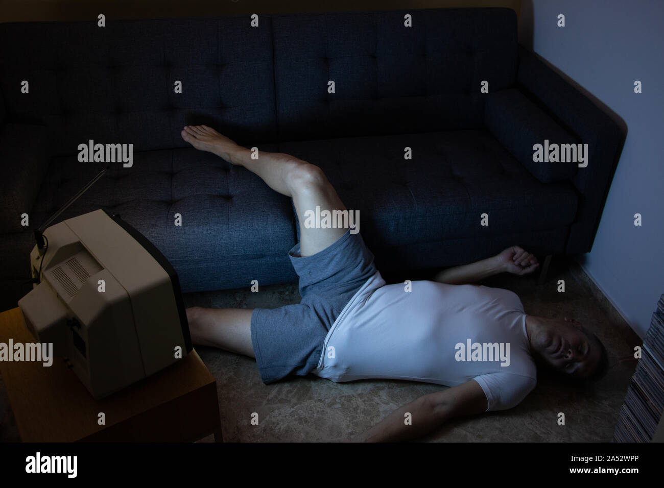 A man falls to the floor from the couch while watching an old ...