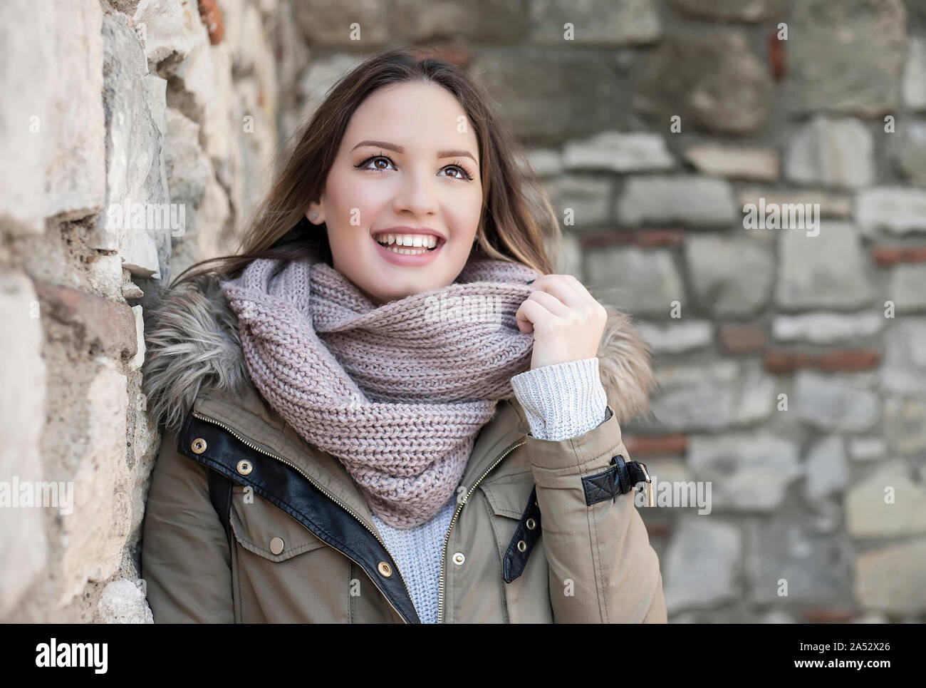 Girl leaning on an old stone wall, laughing Stock Photo - Alamy