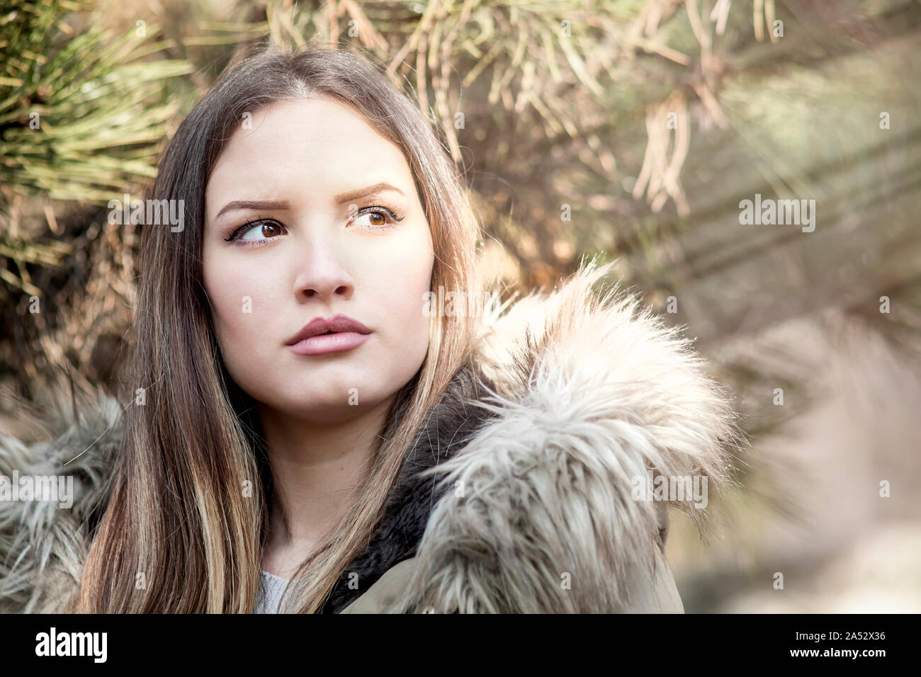 Beautiful young woman looking ahead with light getting on her face ...