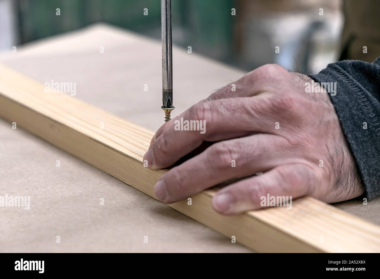 Carpenter tightening the screw in a piece wood Stock Photo - Alamy
