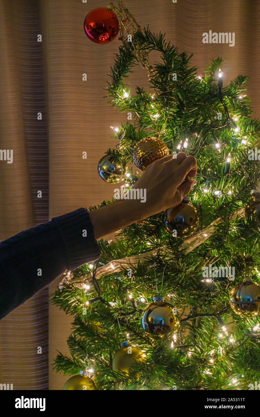 Decorating christmas tree for the holiday seasons Stock Photo - Alamy