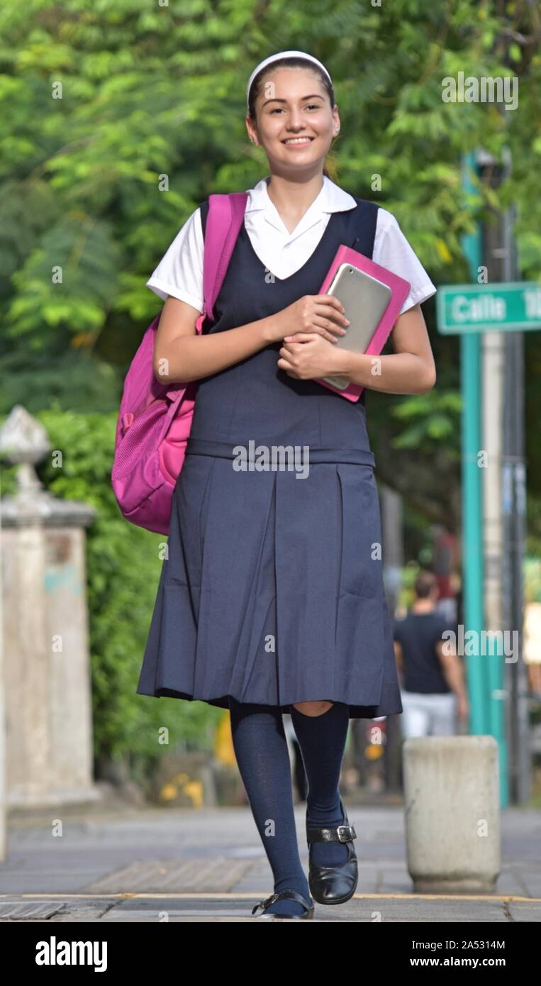 Female Student Wearing Uniform Walking On Sidewalk Stock Photo - Alamy