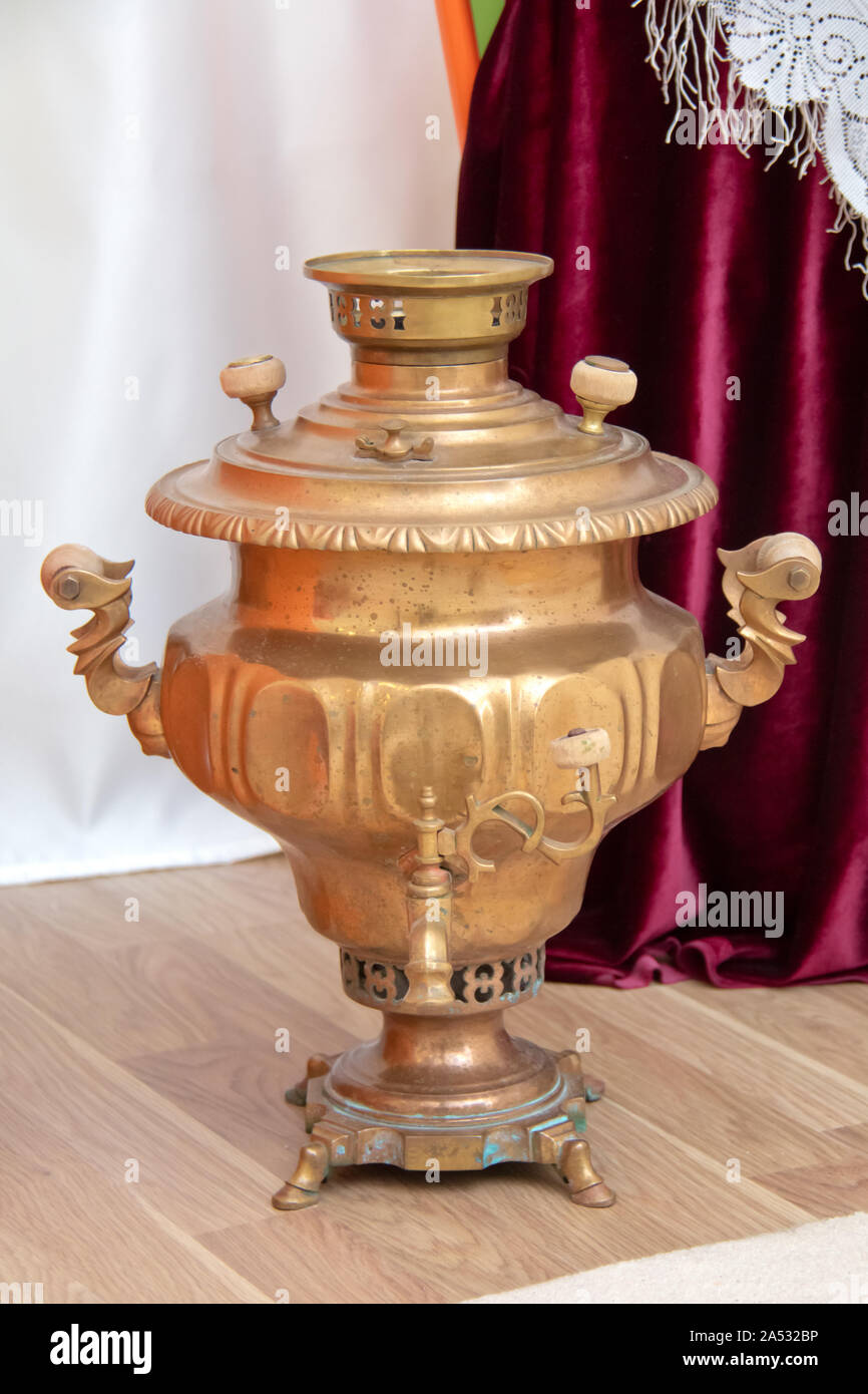 Gold color Metal samovar on a background . Samovars are typically ...