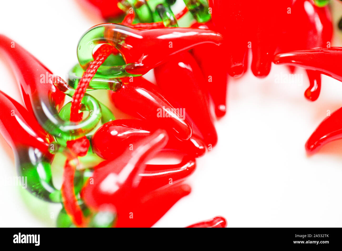 Red glass decorative peppers on white background with copy space ...