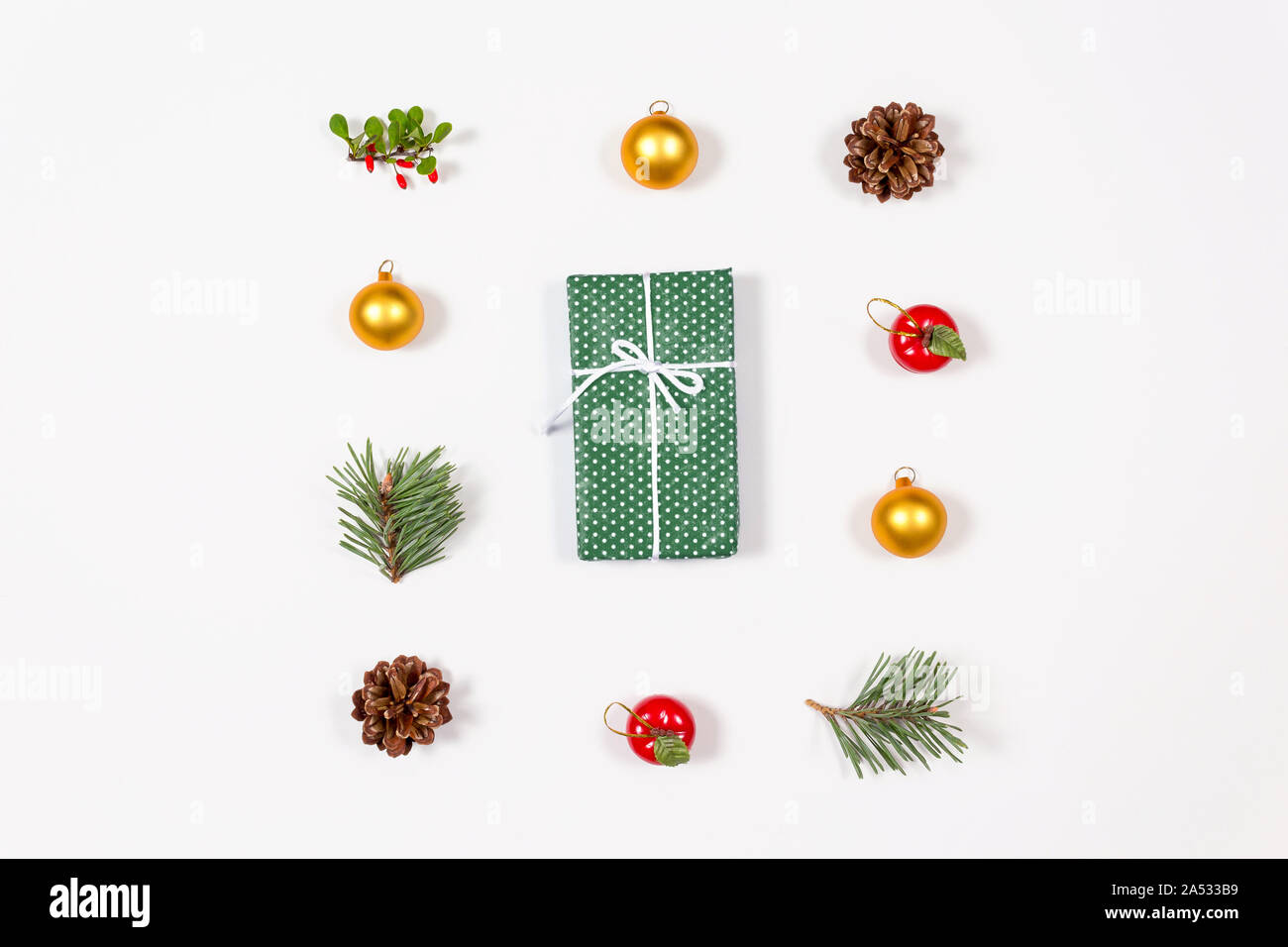 Creative flat lay of winter toys, berries, balls, cones and wrapped ...