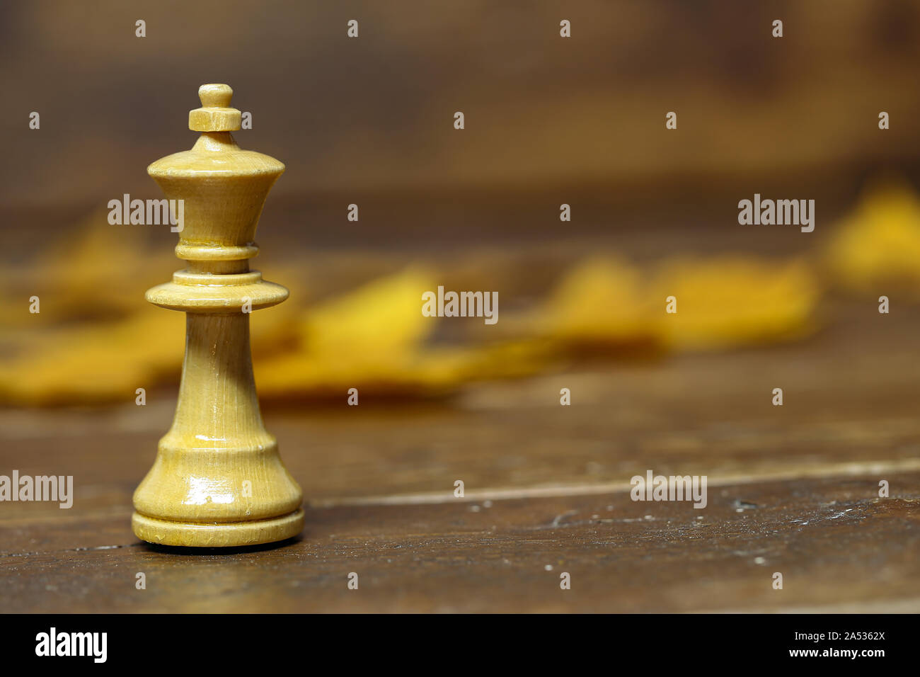 White Queen chess piece on blurred brown background Stock Photo - Alamy