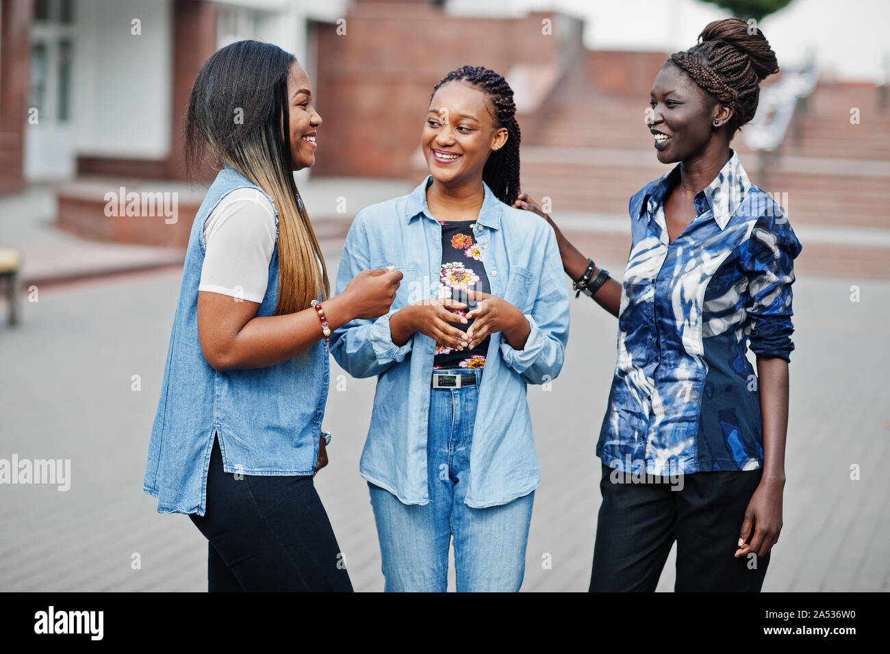 Group of young black female friends hanging out in the city. Multiracial african women walking ...
