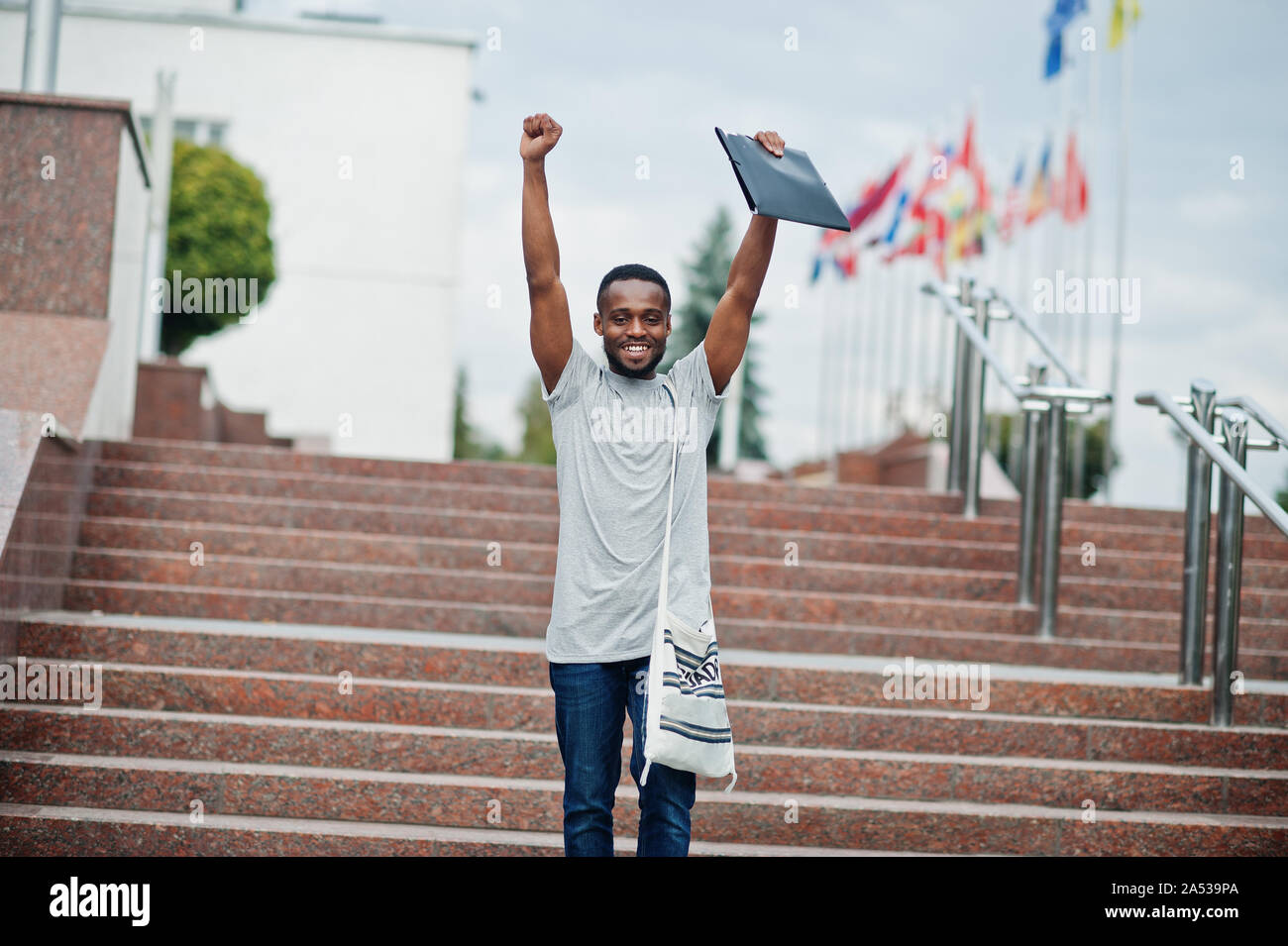 Hands up i am a winner! African student male posed with backpack and ...