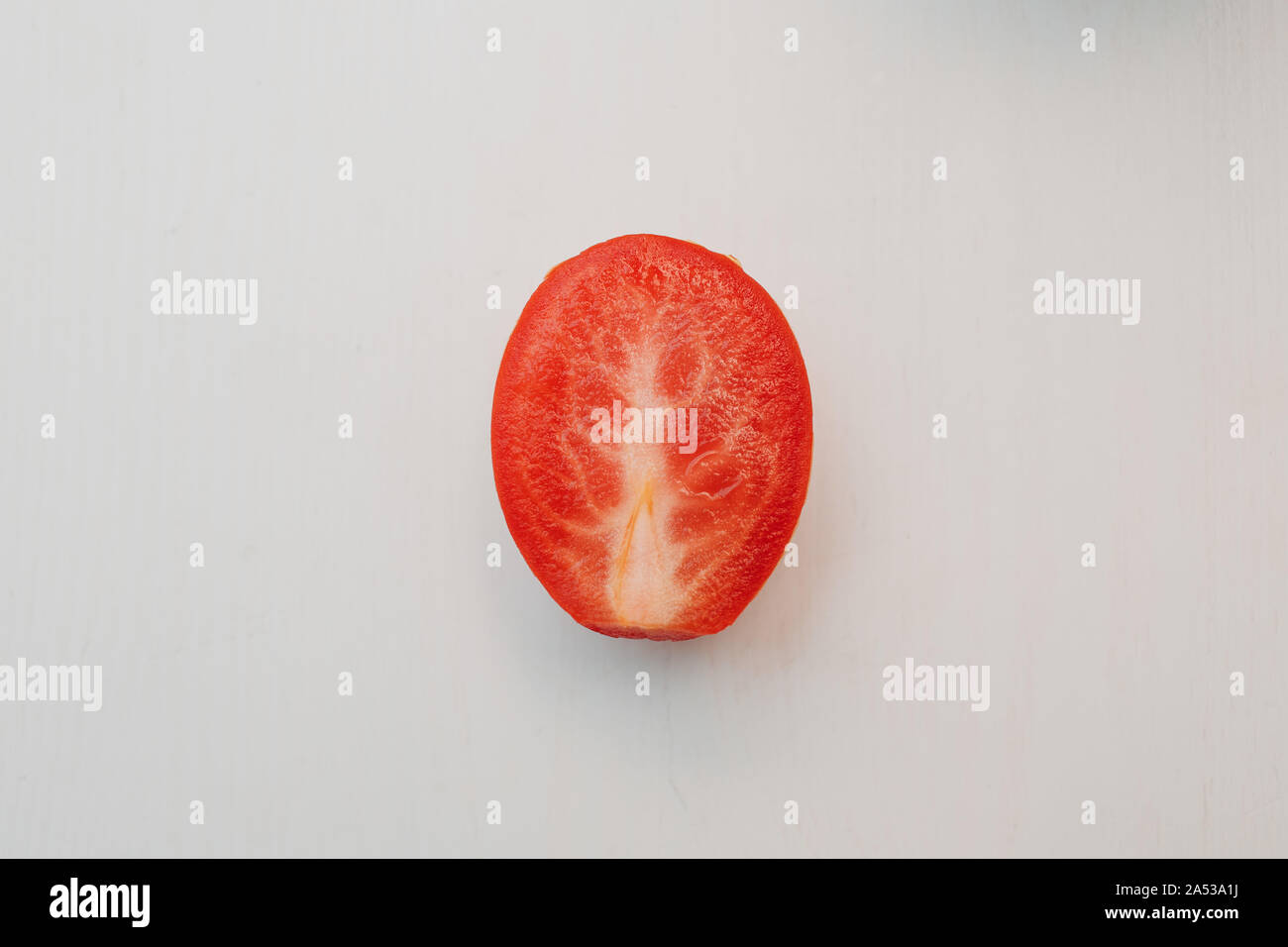Half cut along a tomato with a texture on a white background Stock ...
