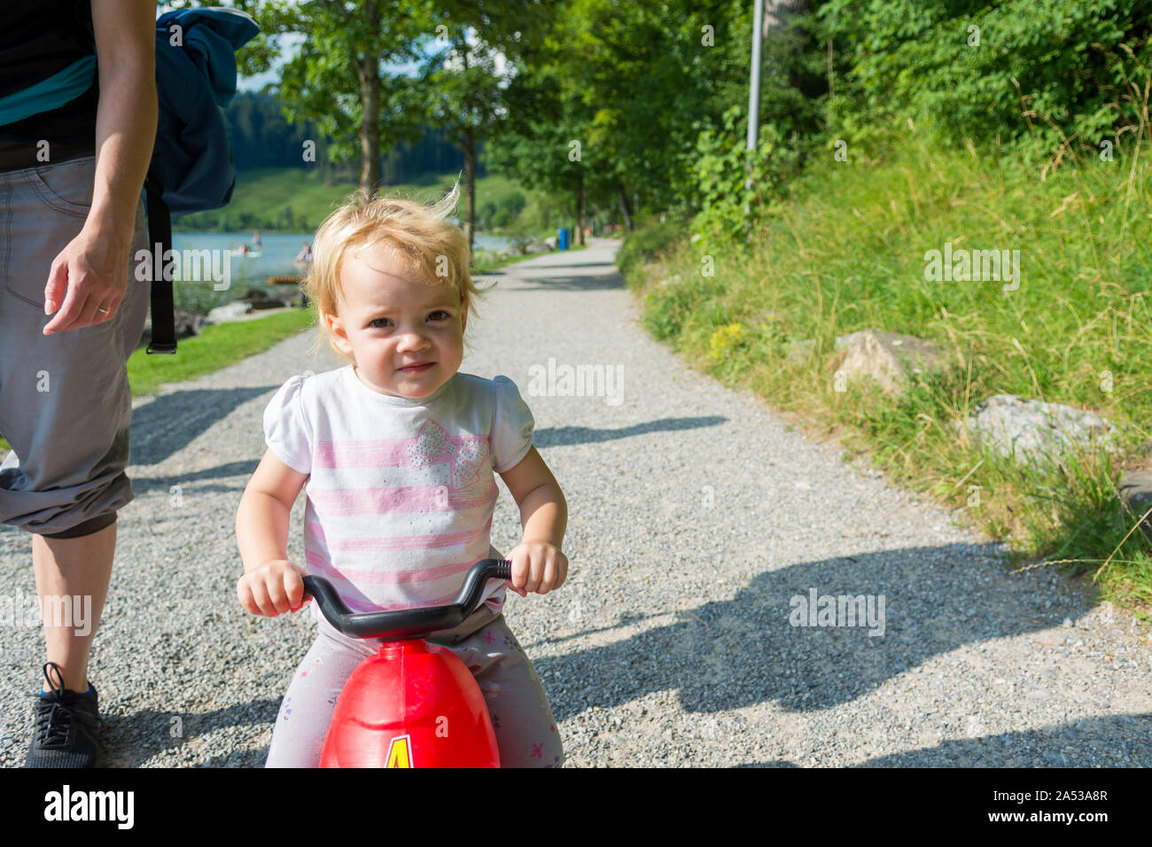 Cute blonde girl riding red motorcycle outdoor Stock Photo - Alamy
