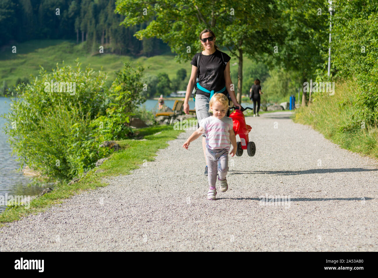 Cute blonde girl running on a path outdoor Stock Photo - Alamy