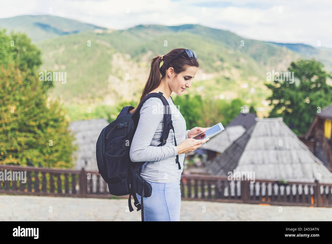 Female tourist holding digital tablet device against beautiful mountain ...